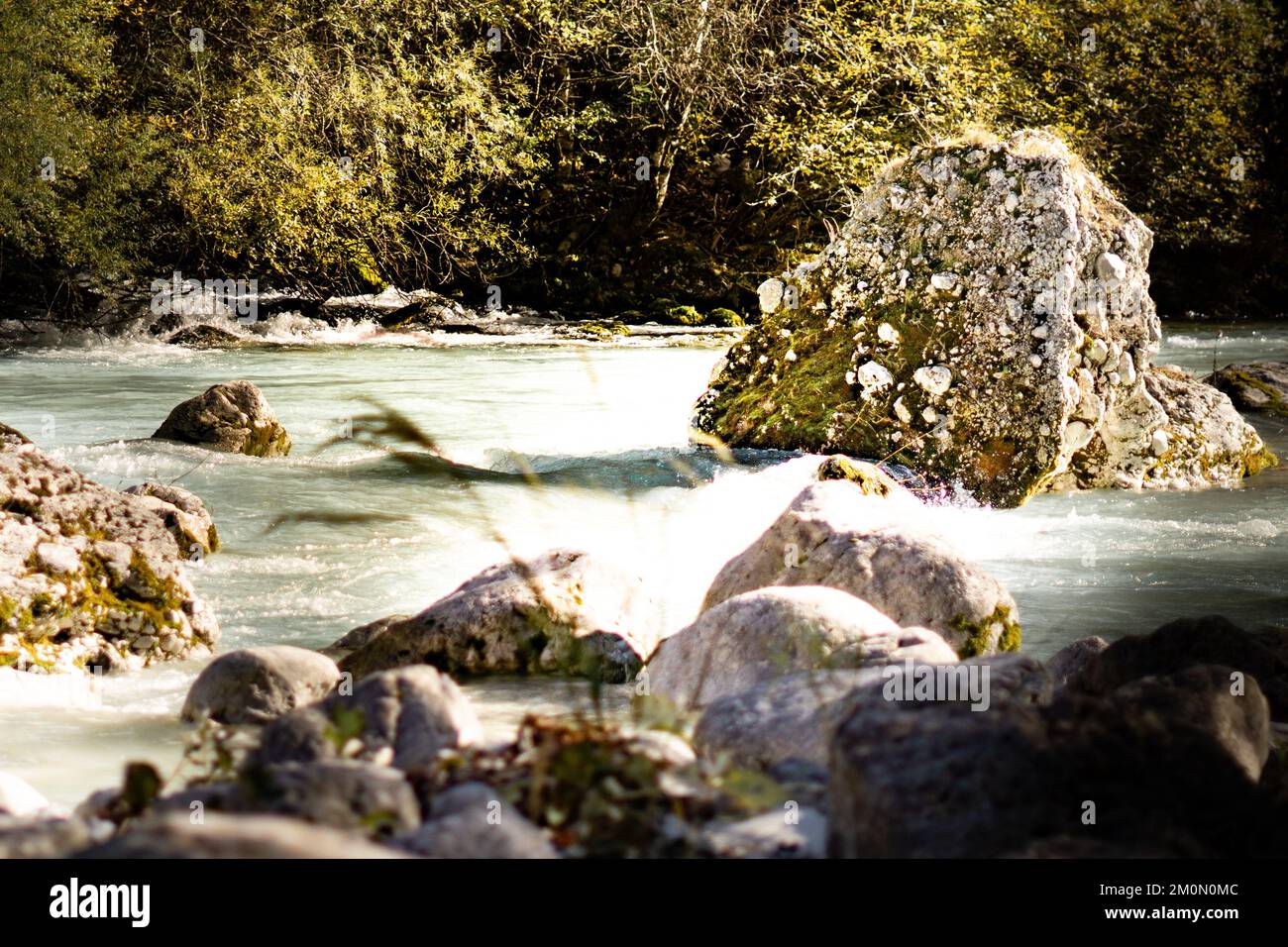 line of rocks in fast running mountain river drawing towards side ...