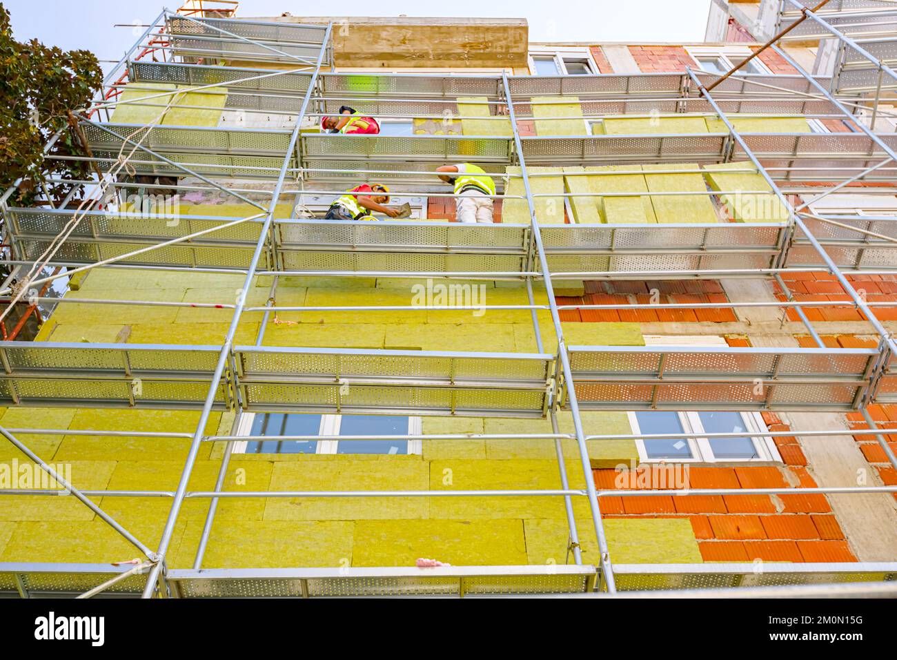 View from below on fenced thermally insulated building. Riggers on ...