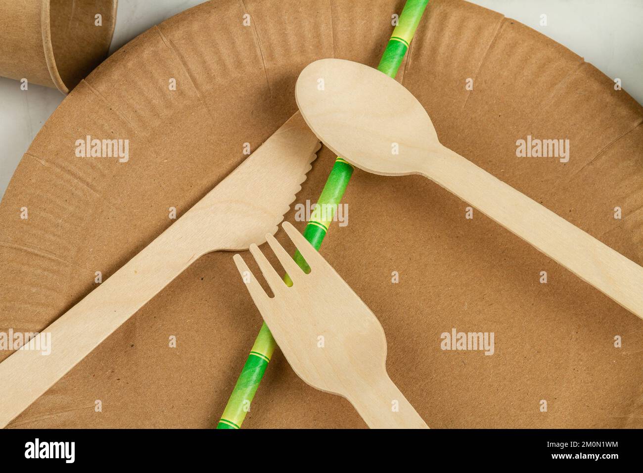 Top view close up wooden utensils and green straw. Plate with flork and ...