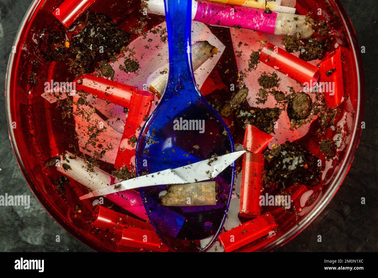 Top view plastis rubbish and cigarettes in a container with water ...