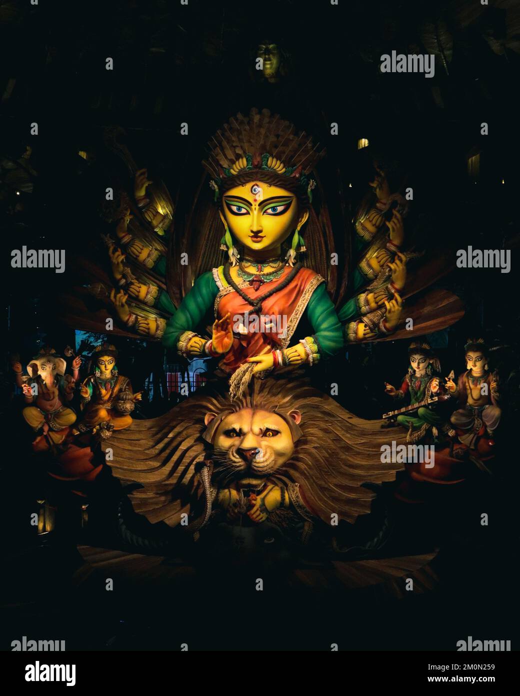A vertical closeup of the Durga goddess statue against the dark ...