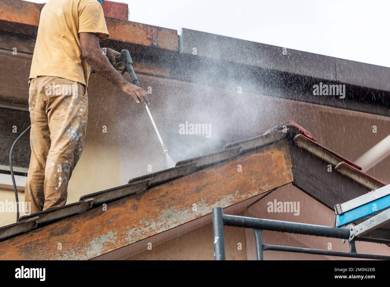 Worker using high pressure water jet spray gun to wash and clean dirt ...