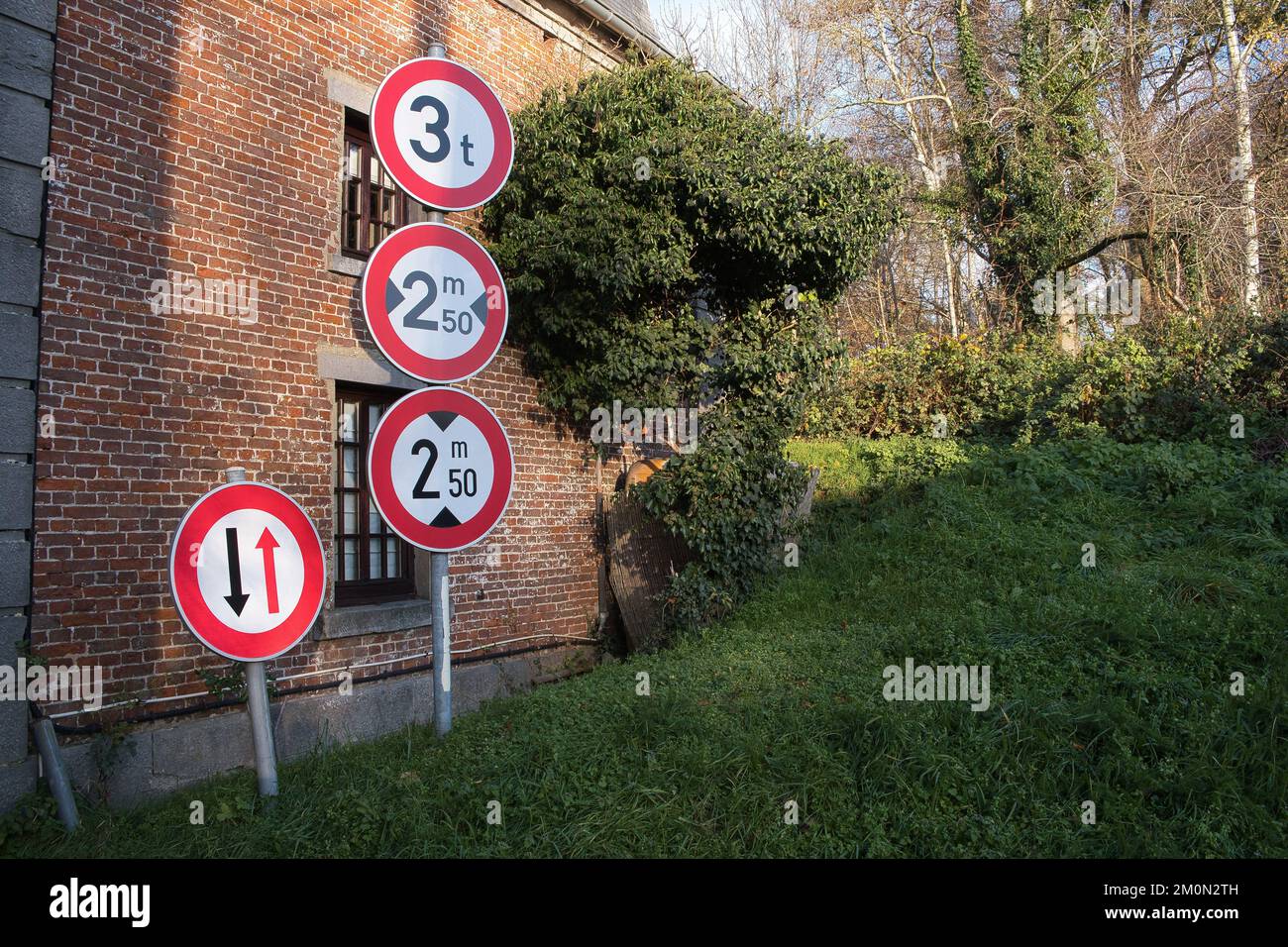 Poles of different road signs showing distance leaning against a ...