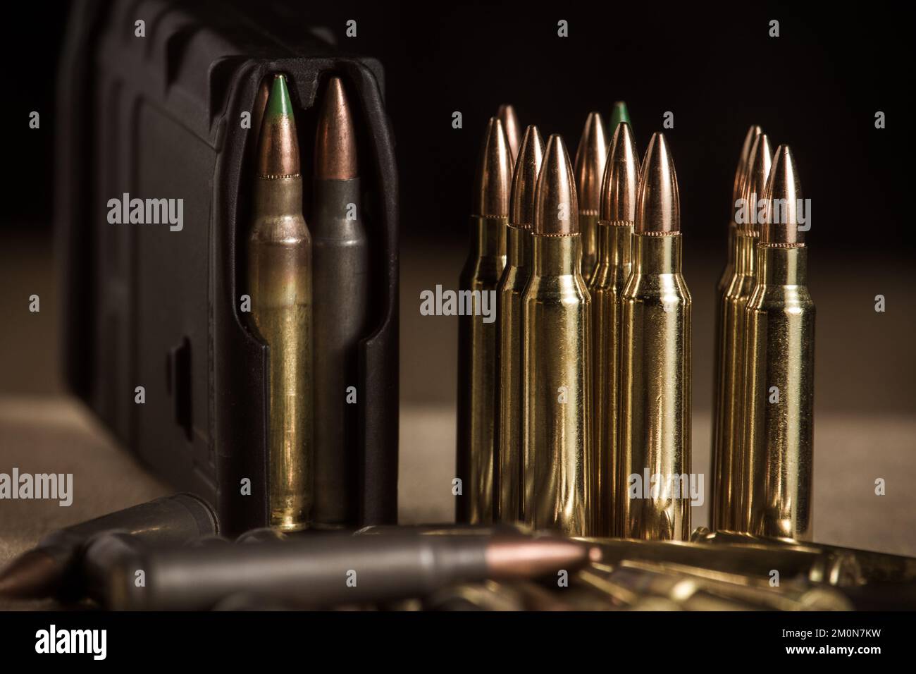 Various 223 caliber (5.56mm) bullets standing or laying next to a full ...