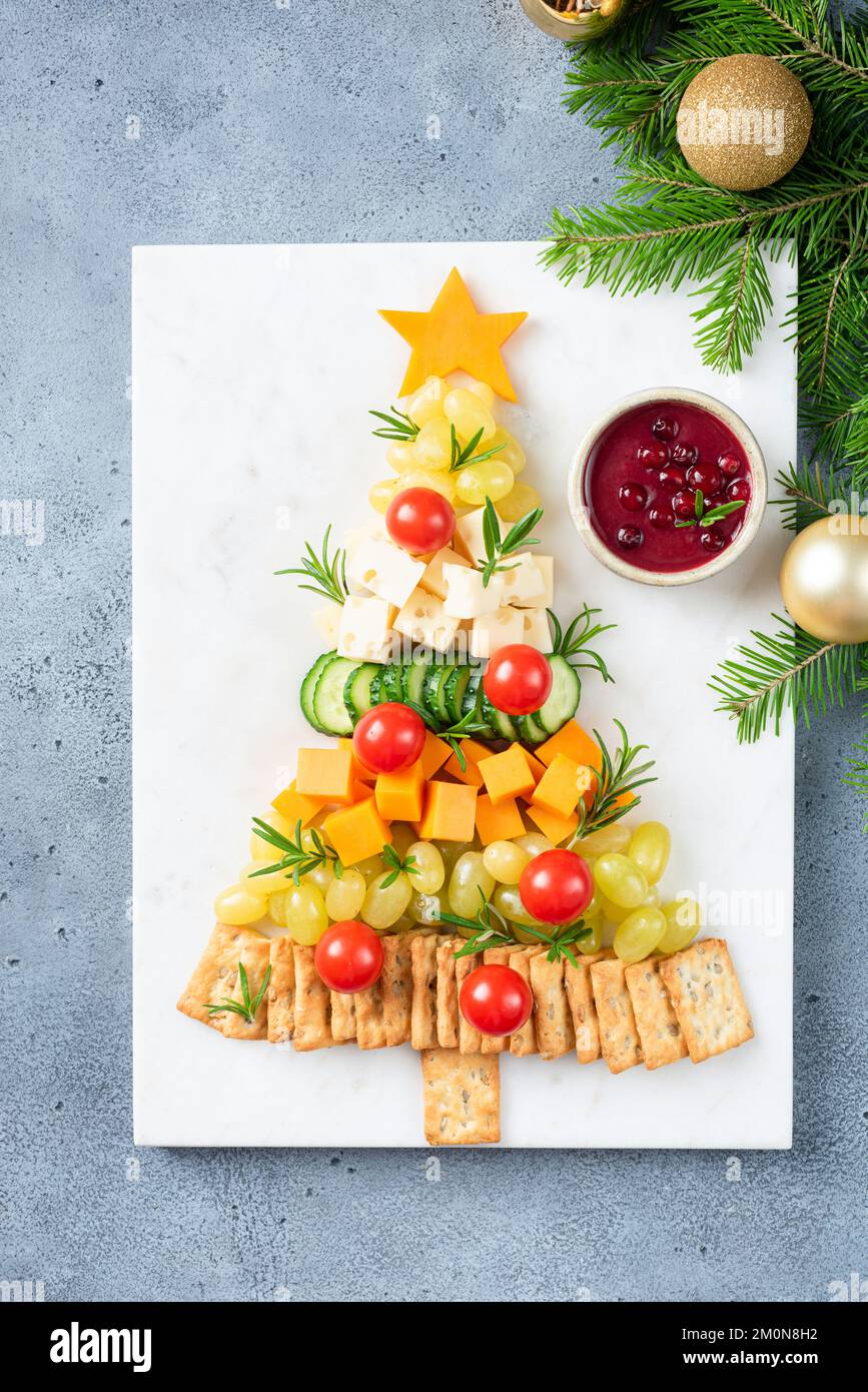 Cheese plate shaped as Christmas Tree on white marble board, top view ...
