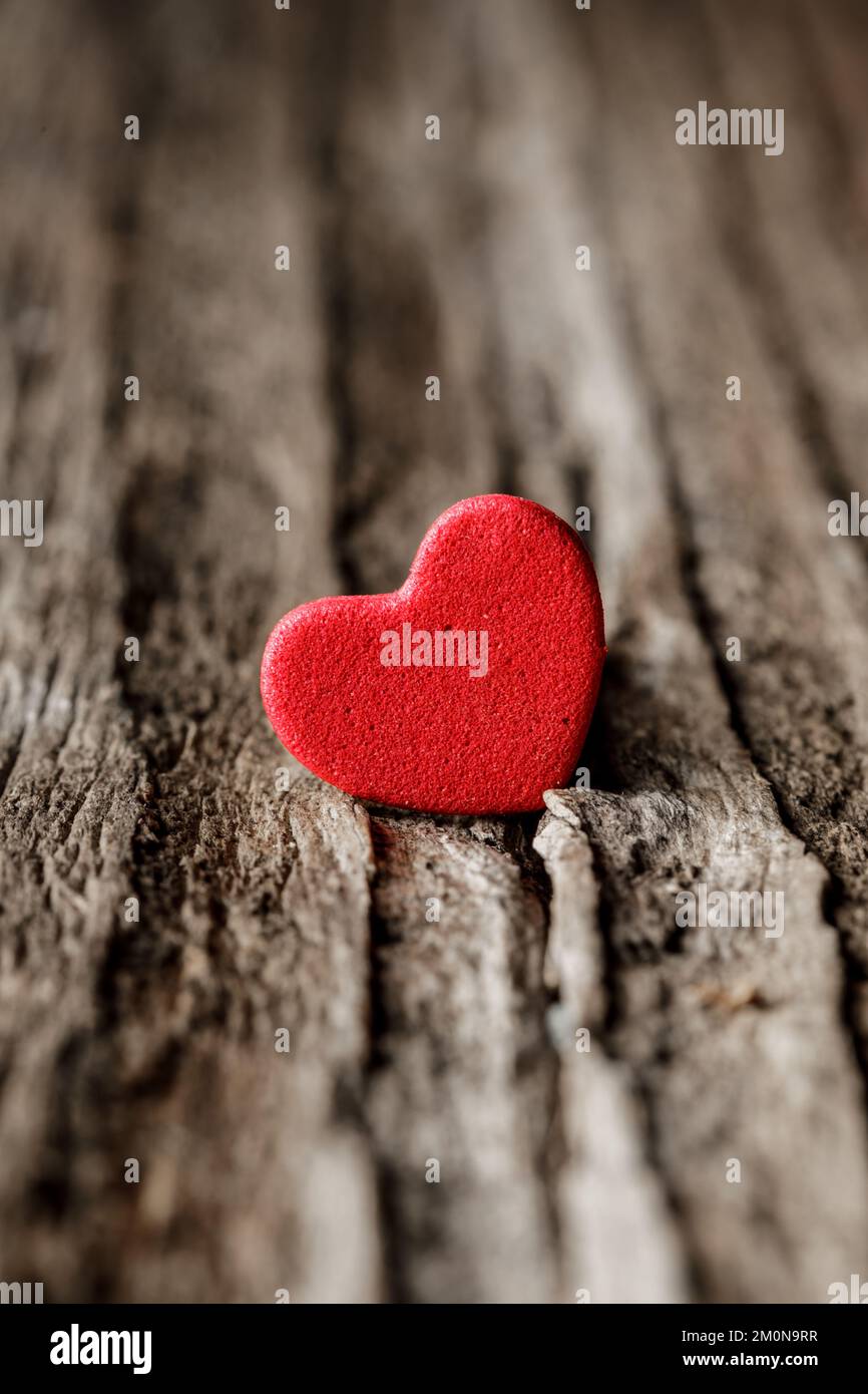 Symbol of love. Miniature red hearth shape on the old wood plank Stock ...