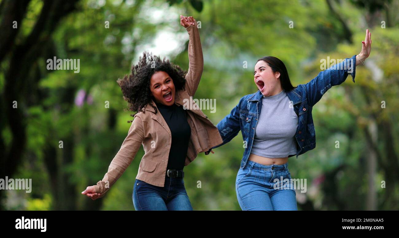 Two women jumping in the air with joy and excitement Stock Photo - Alamy