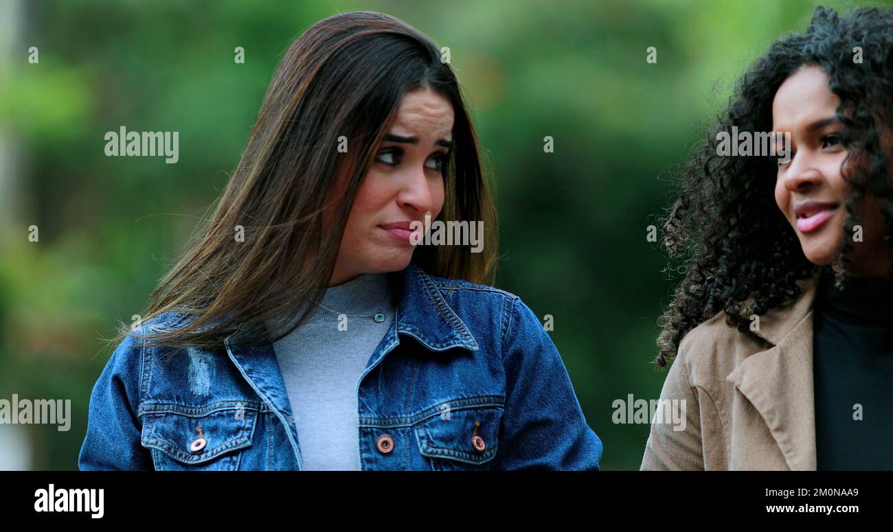 Women walking and talking chatting in conversation showing concern ...