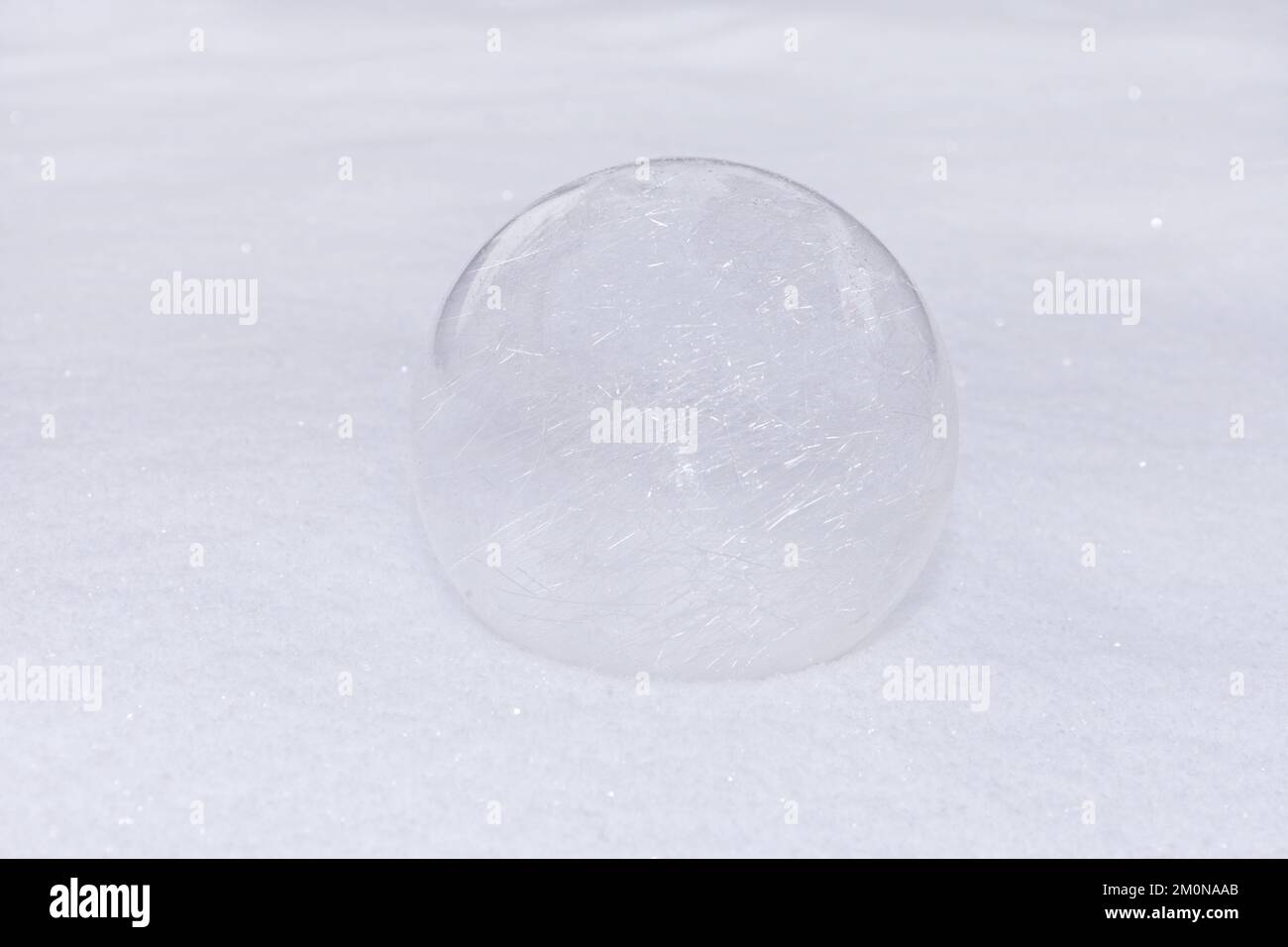 glass ball or transparent bauble on white snow. winter outdoors ...