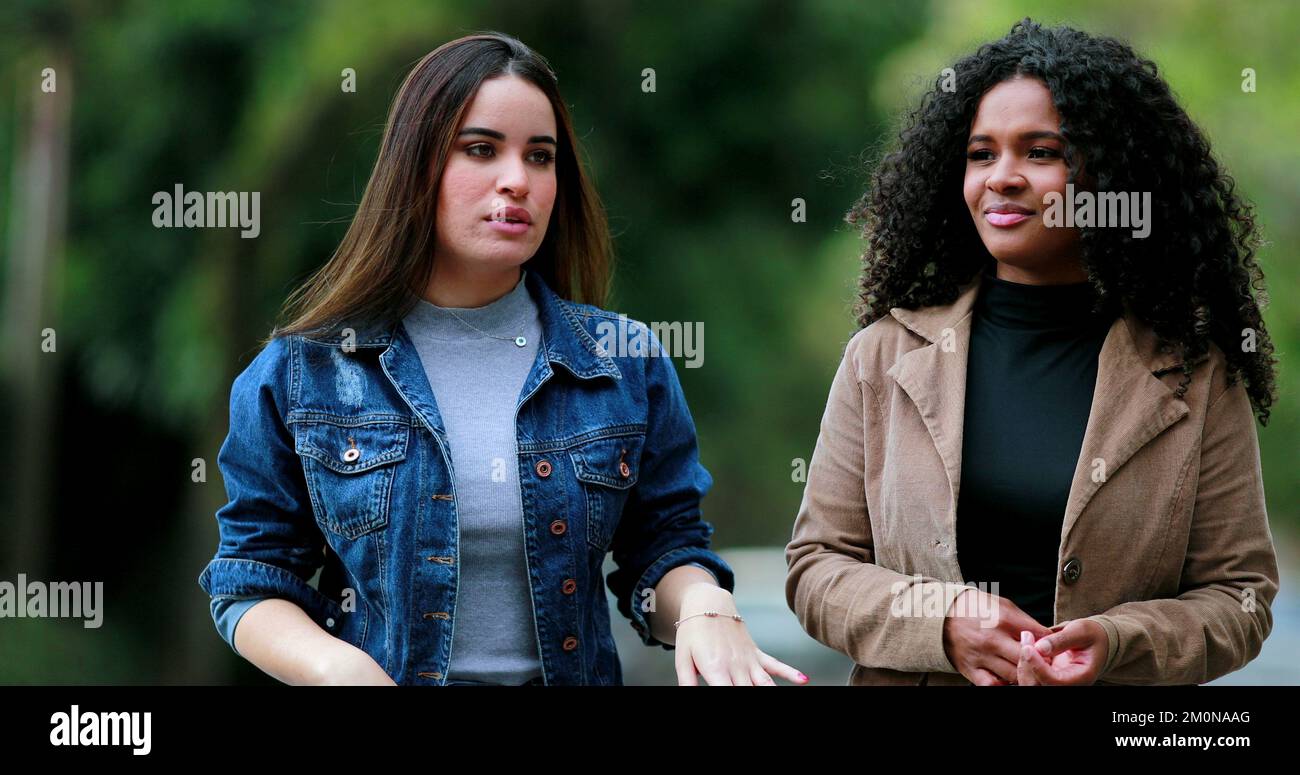 Women walking and talking chatting in conversation showing concern ...