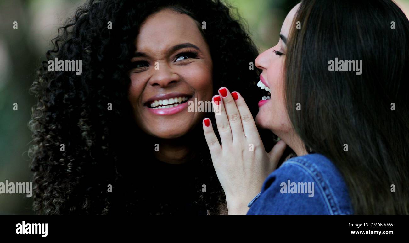 Two women sharing gossip secret laughing. Candid spontaneus laugh Stock ...