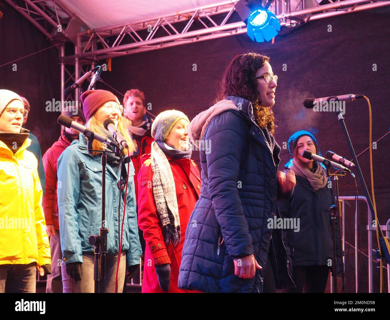 Young choir singers performing on a stage outside in the winter ...
