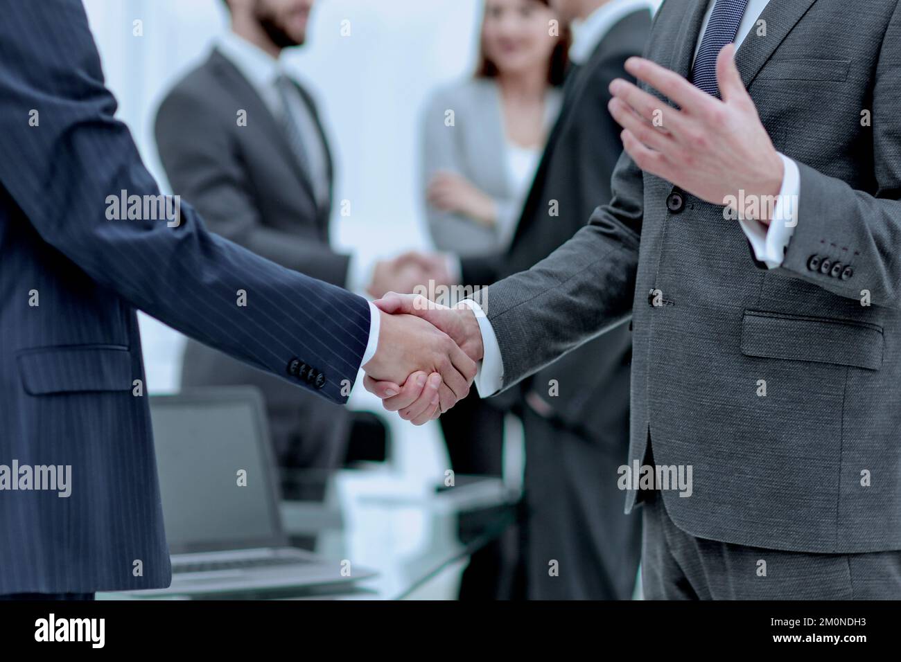 Business partners handshaking over business objects on workplace Stock ...