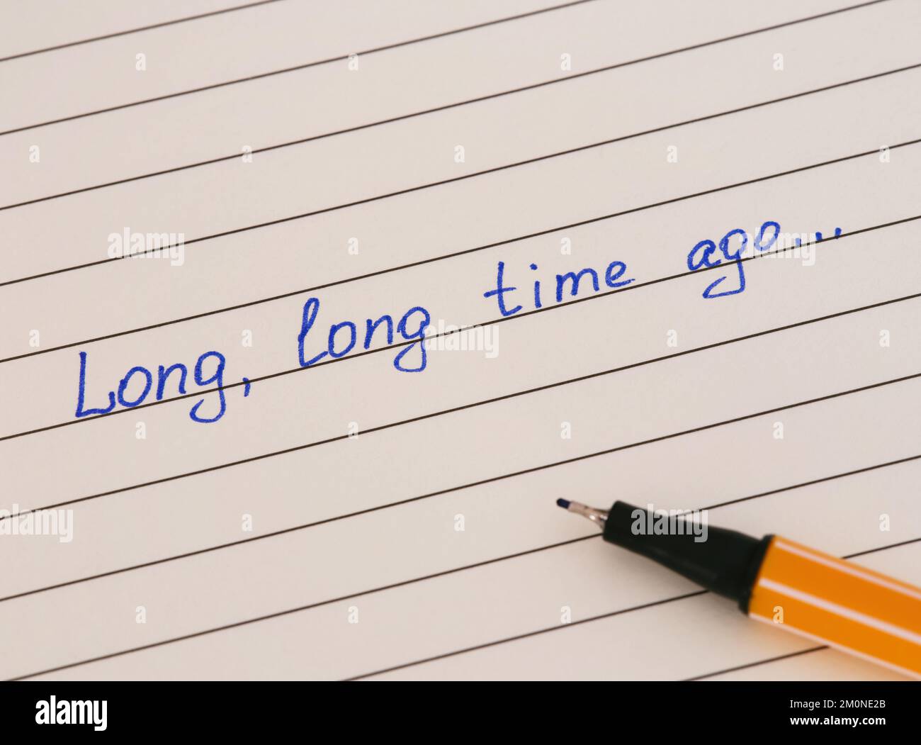Handwriting text Long, Long Time Ago... on a lined paper with a pen ...
