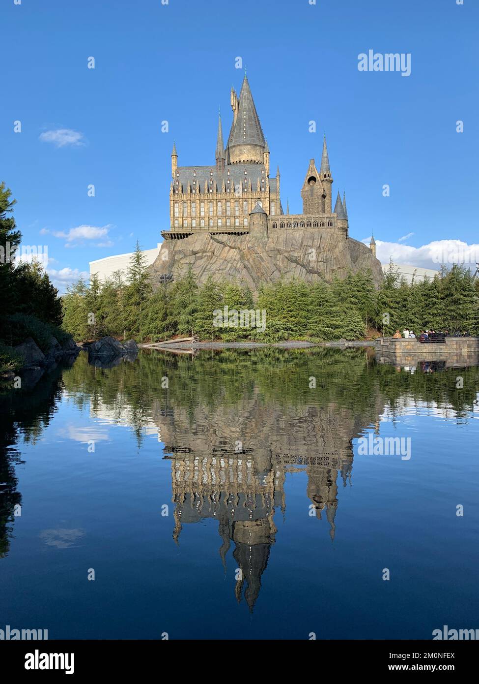 A vertical shot of a medieval castle reflecting on the lake water with ...
