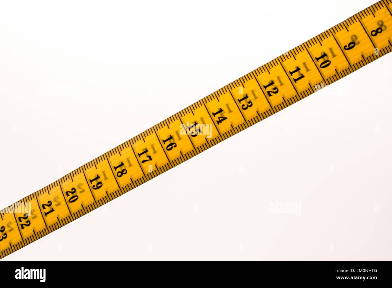 Yellow color measuring tape on a white background Stock Photo - Alamy