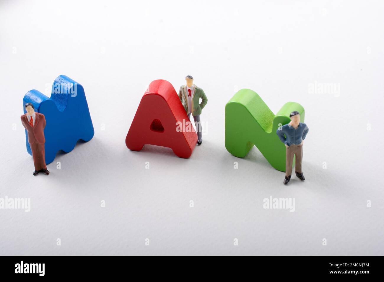 Tiny figurine of men beside colorful wooden letters say MAN Stock Photo ...