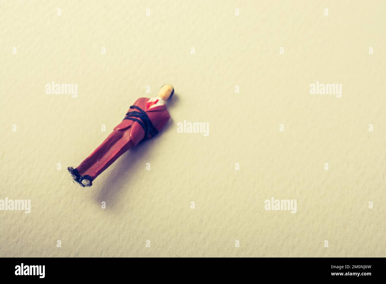 Tiny figurine of man miniature model tied in rope Stock Photo - Alamy