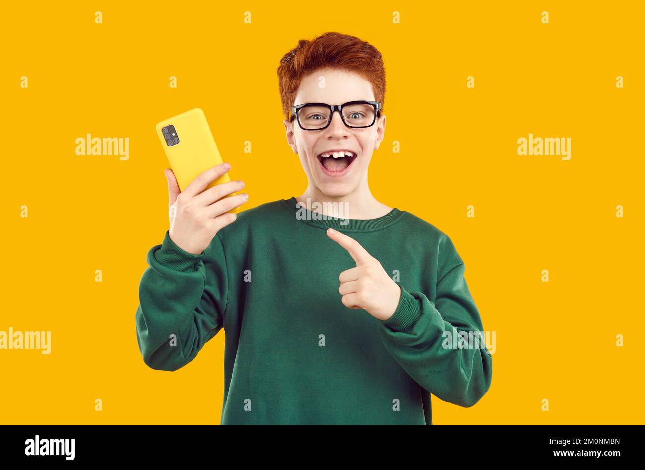 Happy amazed boy pointing his finger at smartphone Stock Photo - Alamy