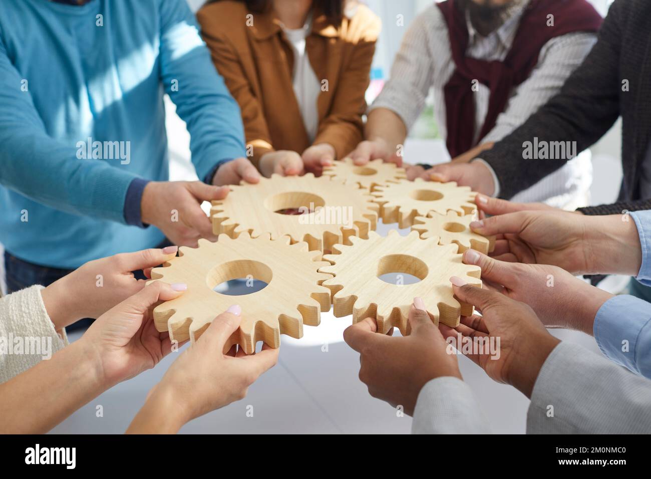 Team of business people connecting gear wheels to show concept of ...