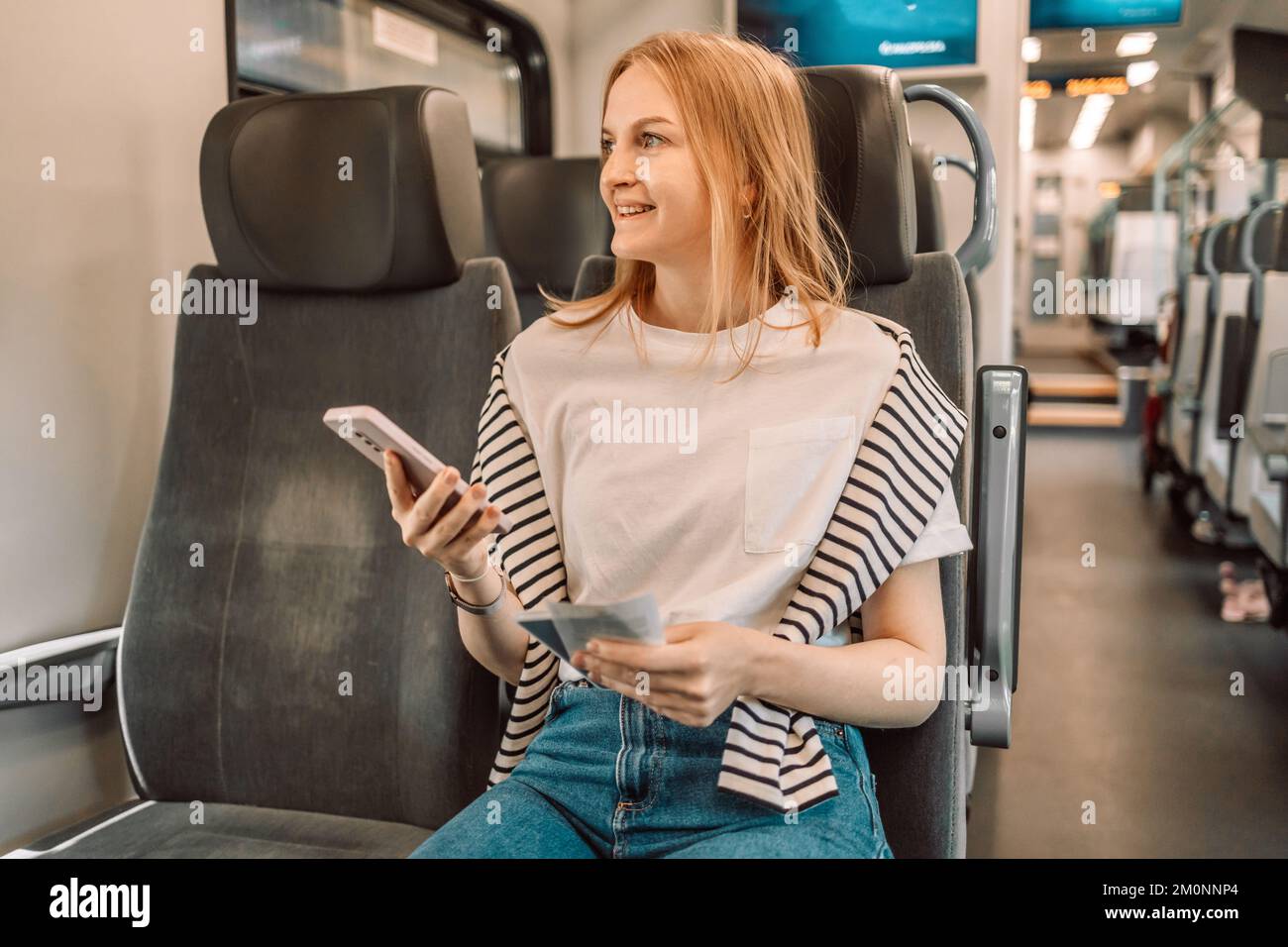 Portrait of a smiling lovely girl typing message on mobile phone in ...