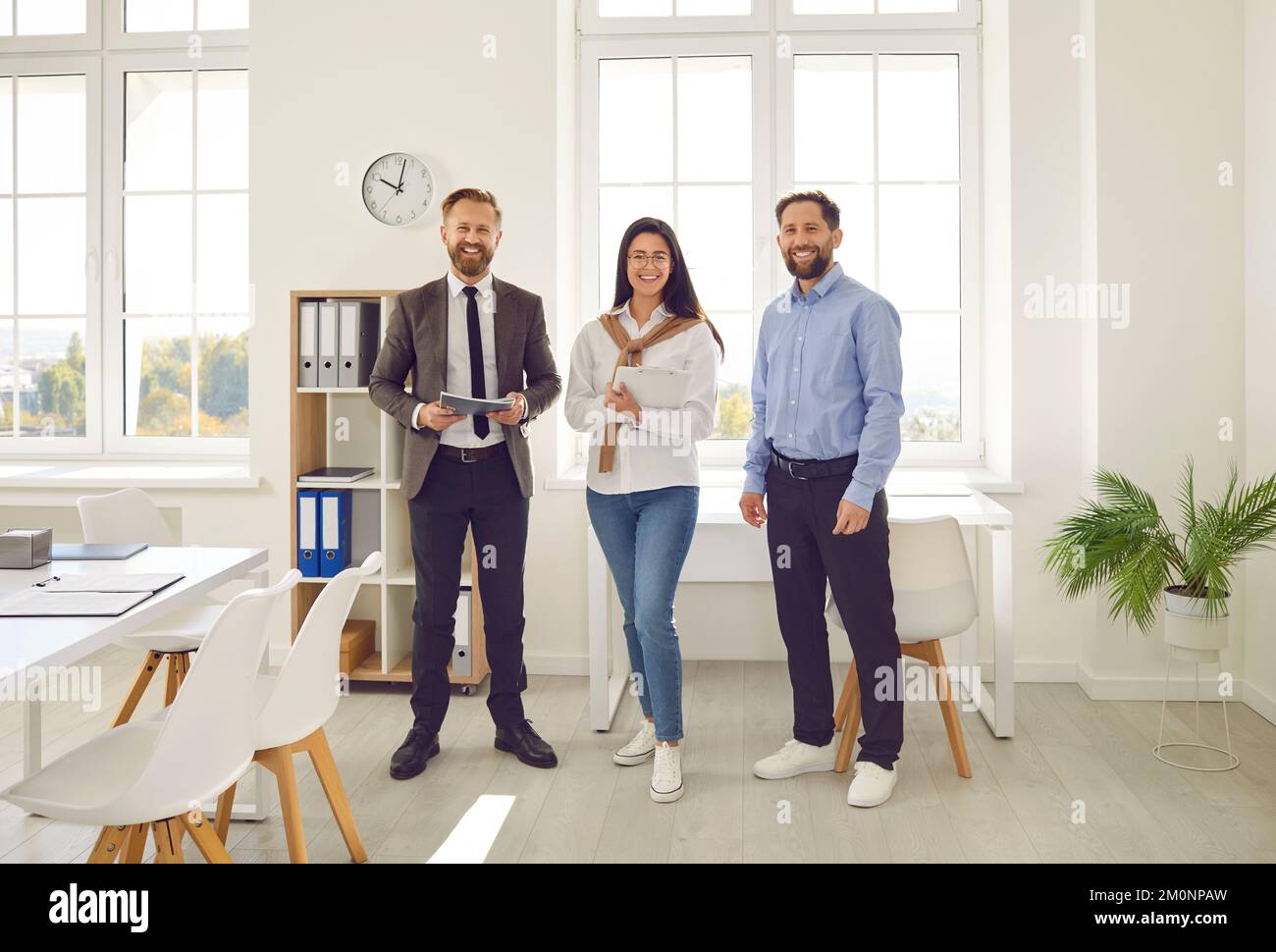 Portrait of three joyful business team colleagues posing together ...