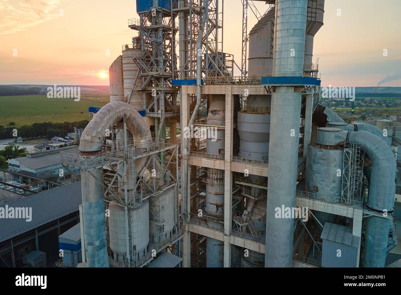Cement plant with high factory structure and tower cranes at industrial ...