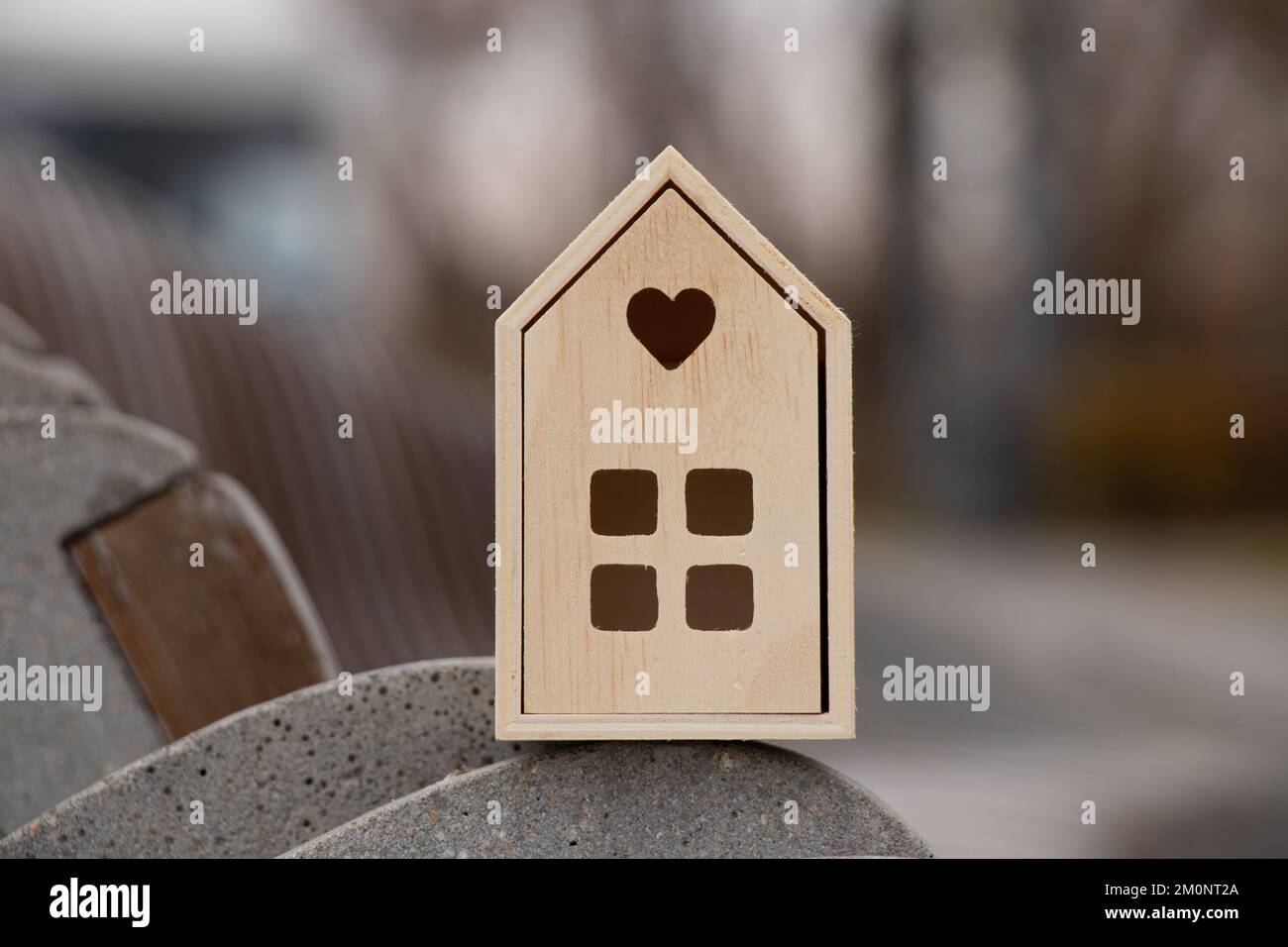 A small wooden house stands on a striped wavy stone background, a dream ...