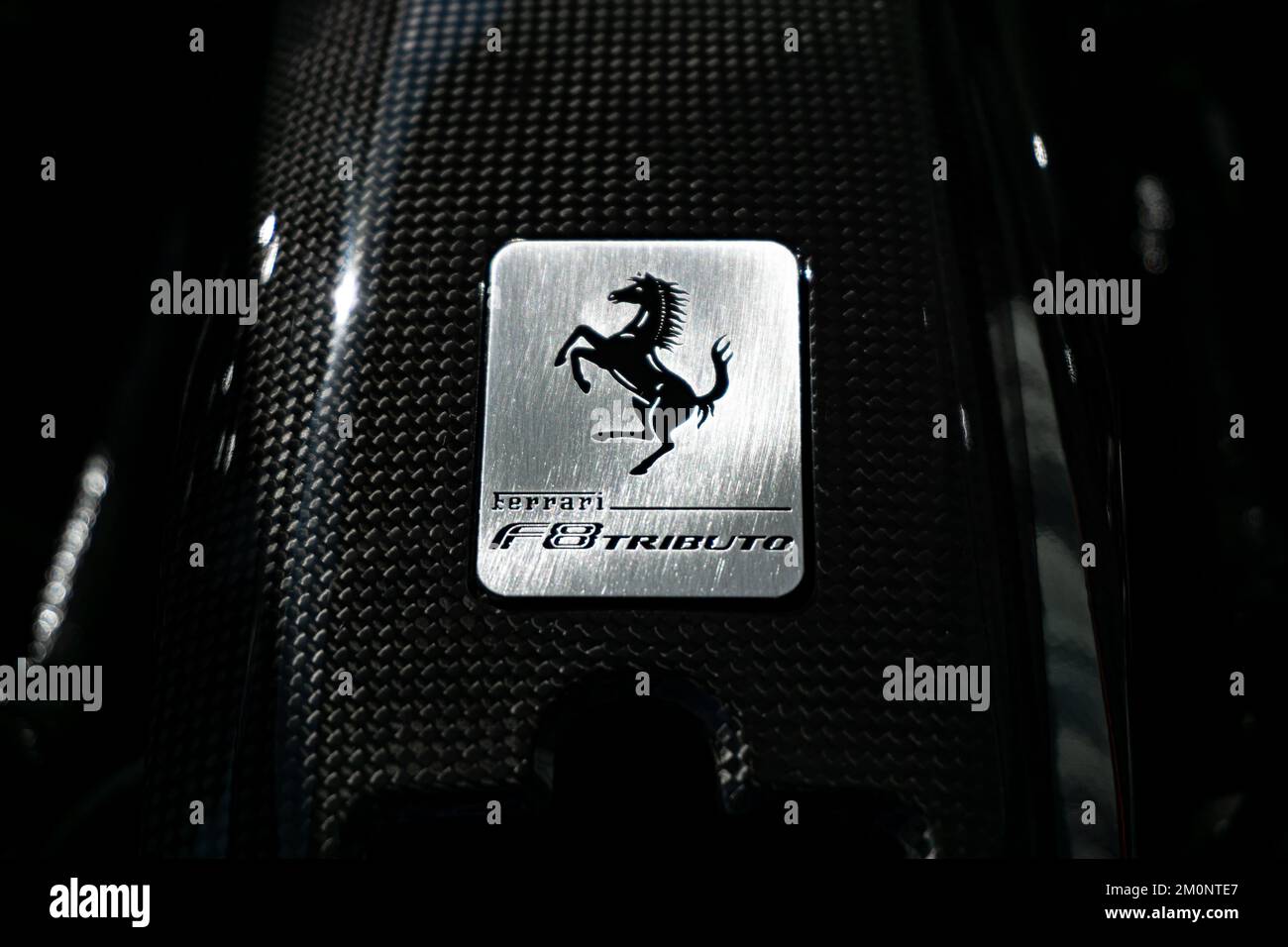 The Ferrari F8 Tributo engine bay plaque on carbon fiber surface Stock ...