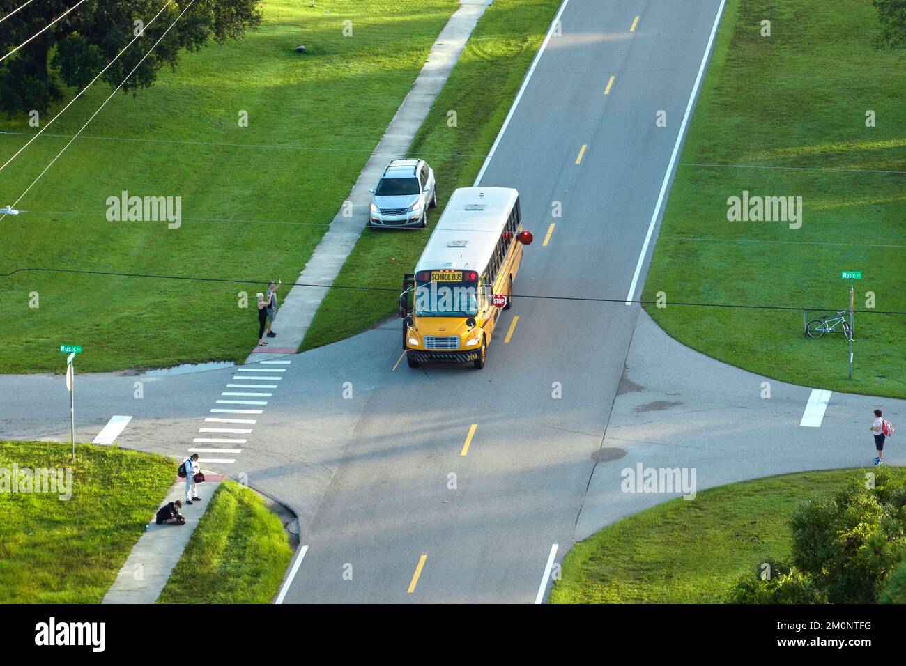 Top view of standard american yellow school bus picking up kids at ...