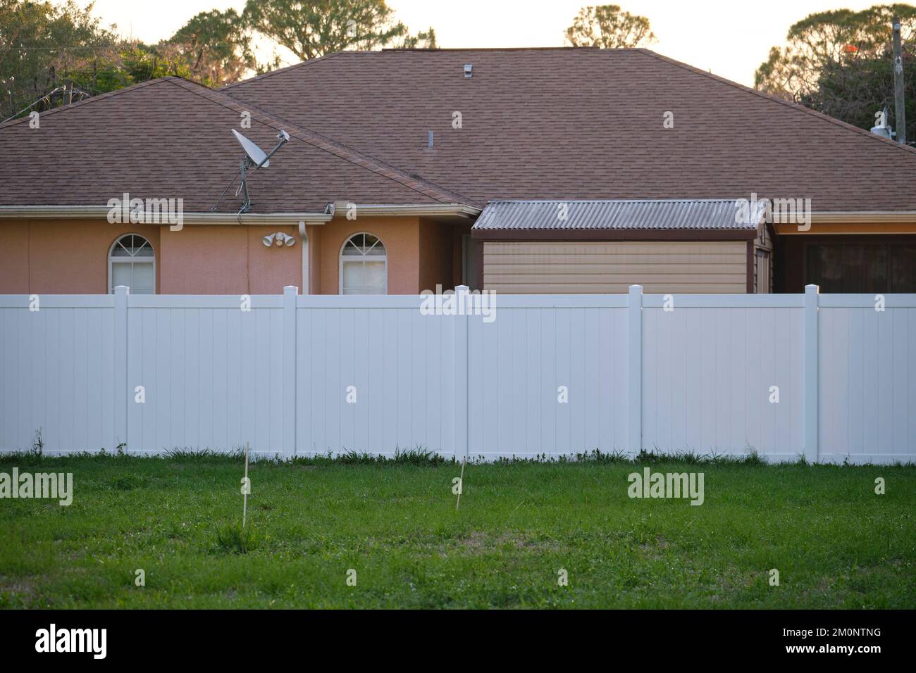 White plastic fence for back yard protection and privacy Stock Photo - Alamy
