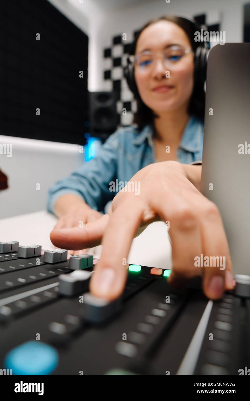 Beautiful happy young female radio host using headphones and sound ...