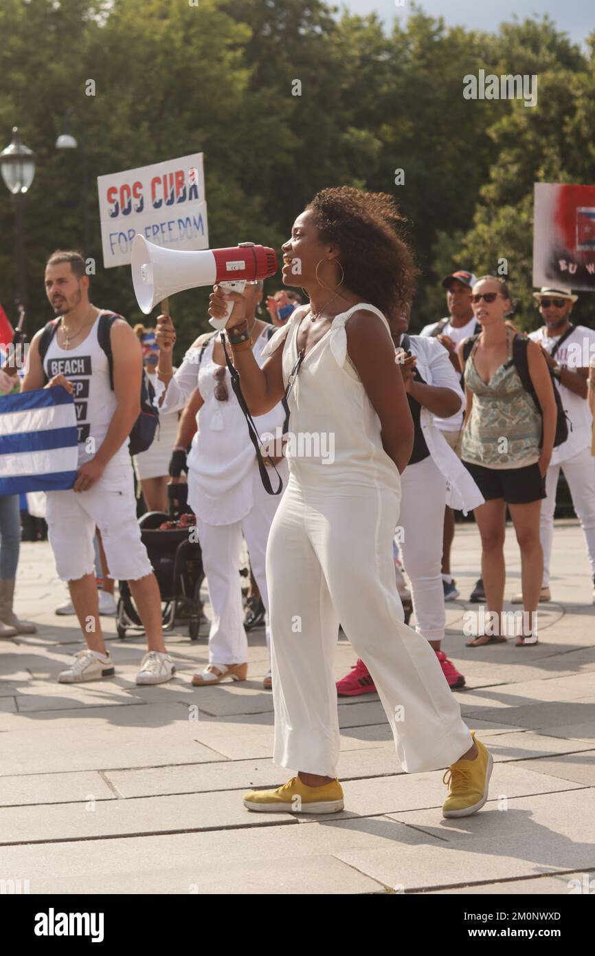 A vertical shot of a female speaking on a megaphone in the background ...