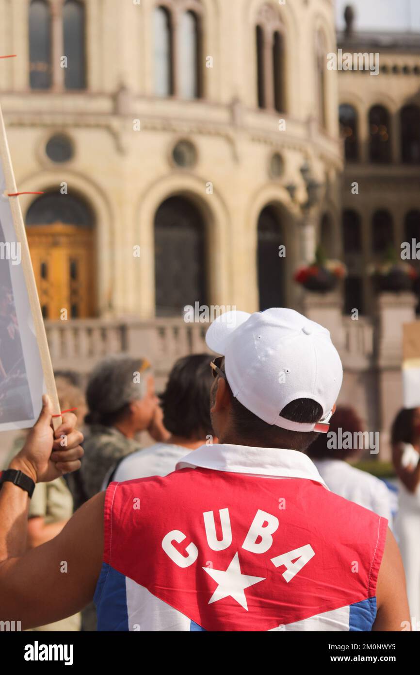 A vertical shot of a male wearing a Cuban flag vest during a rally on ...