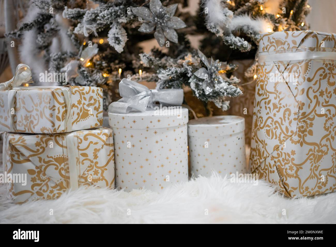 Beautiful Christmas gift boxes on floor near fir tree in room Stock ...