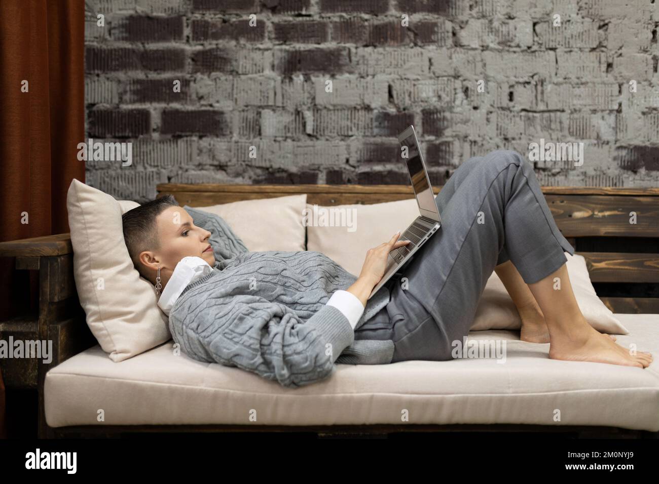 tired caucasian woman relaxing while watching series on laptop while ...