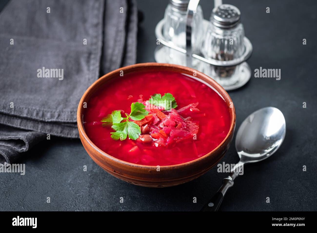 Borscht, Ukrainian beetroot soup in a bowl on elegant black table ...