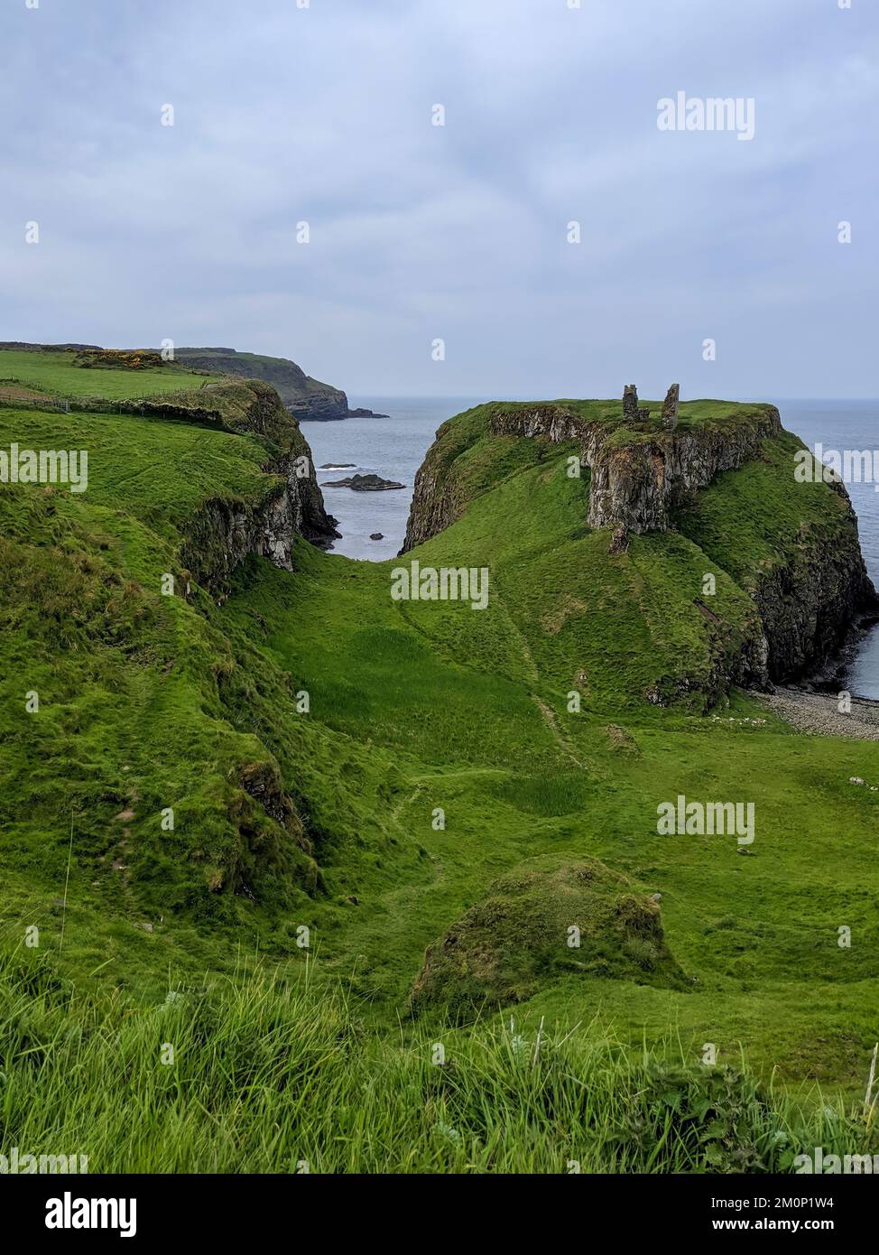 The Dunseverick castle with green grass on rocky cliffs gloomy seascape ...