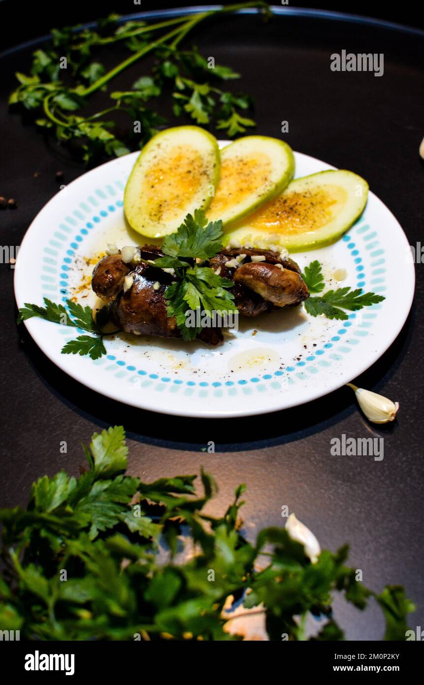 A chicken liver with slices of zucchini on the plate Stock Photo - Alamy