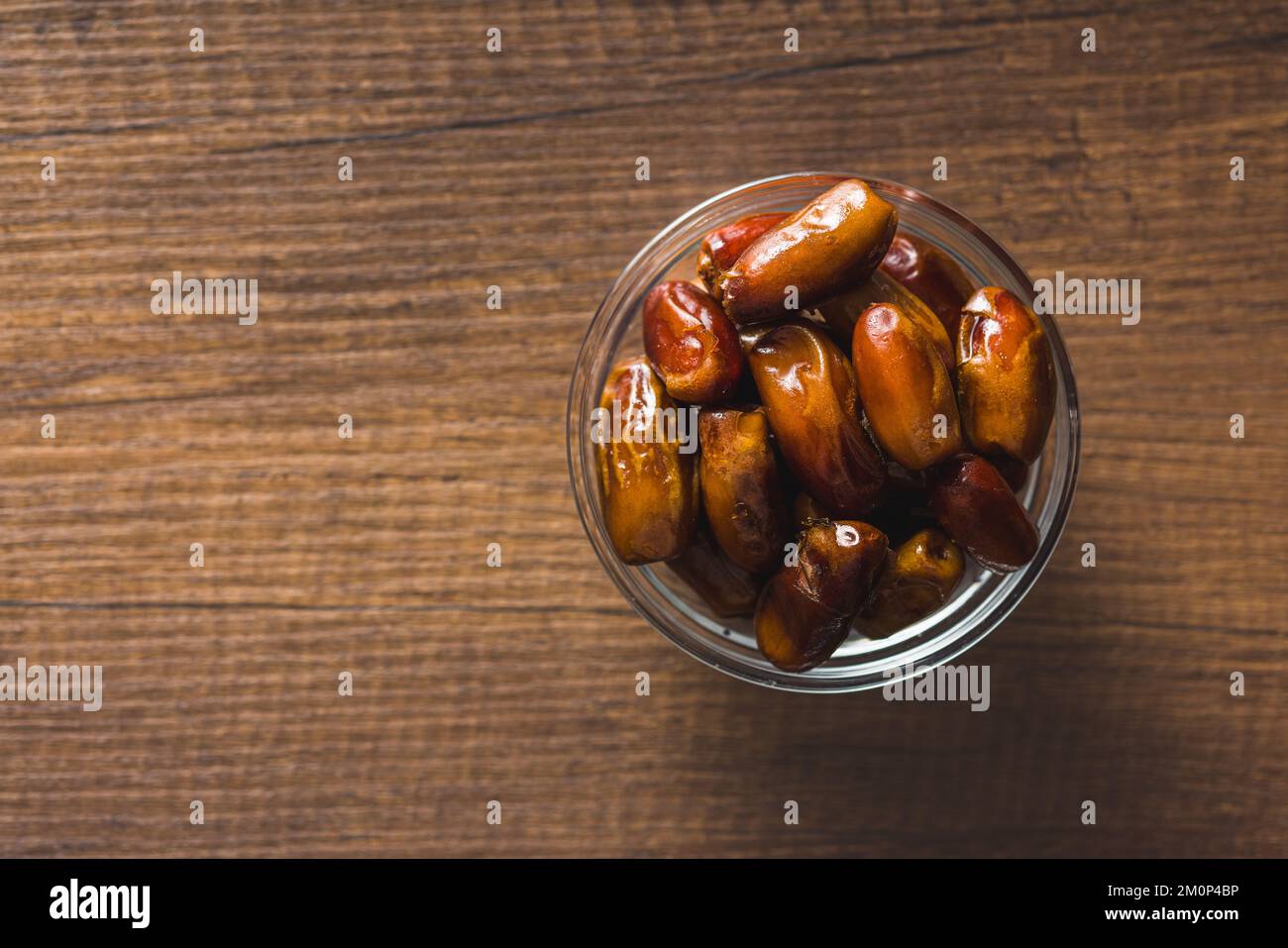 Dried dates fruit in bowl on the wooden table. Top view Stock Photo - Alamy