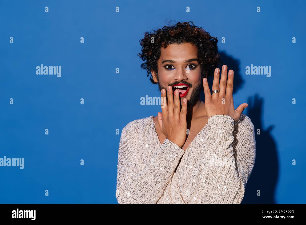 Young excited man with makeup expressing surprise at camera isolated ...