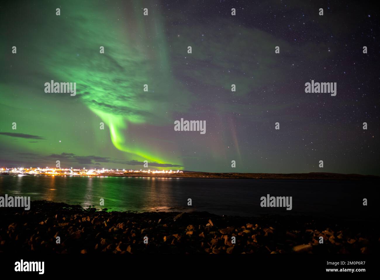 A beautiful shot of the Northern Lights over a sea in Vardo, Norway ...