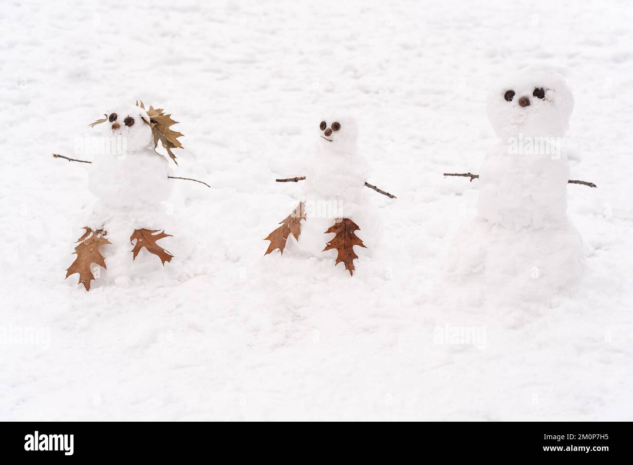 Cute three white snowmen standing at the snowy ground background Stock ...