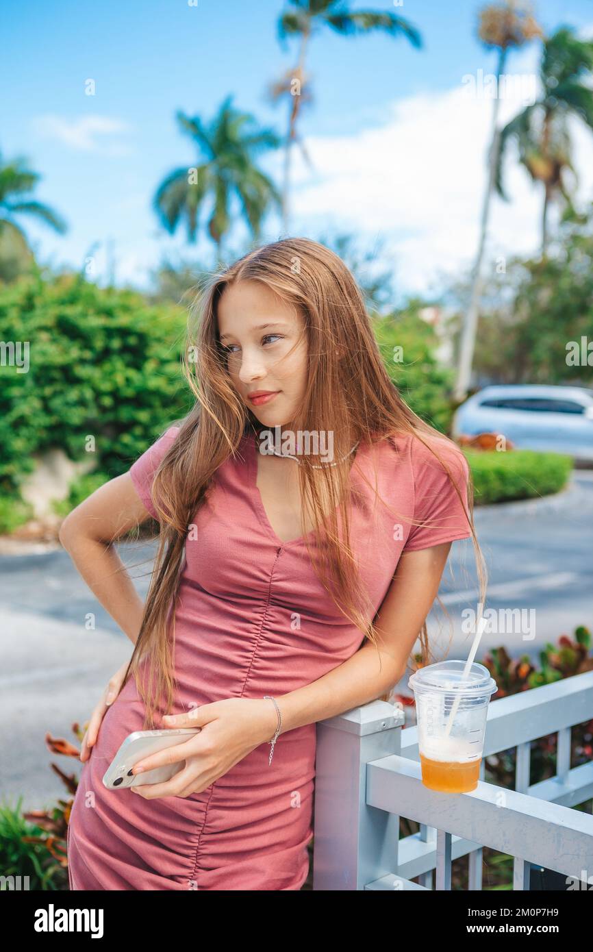 Portrait of adorable teen girl with smartphone and take away drink ...