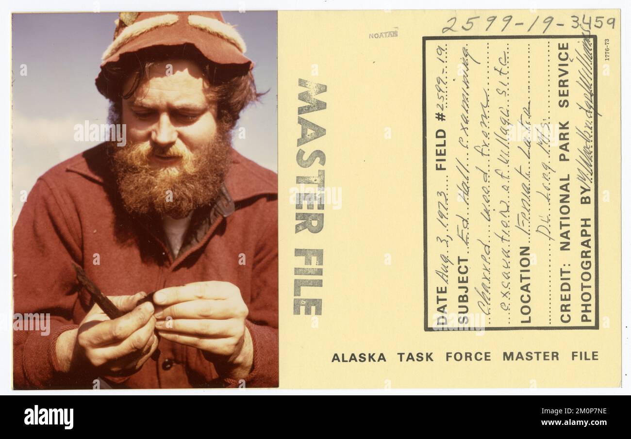 Ed Hall examining charred wood from excavation of village site. Alaska ...