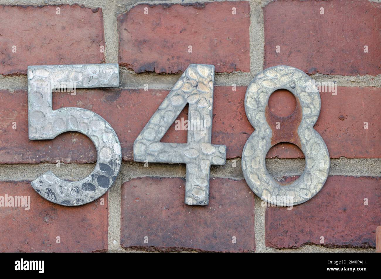 A sign on a wall with the number five hundred forty-eight-548 Stock ...