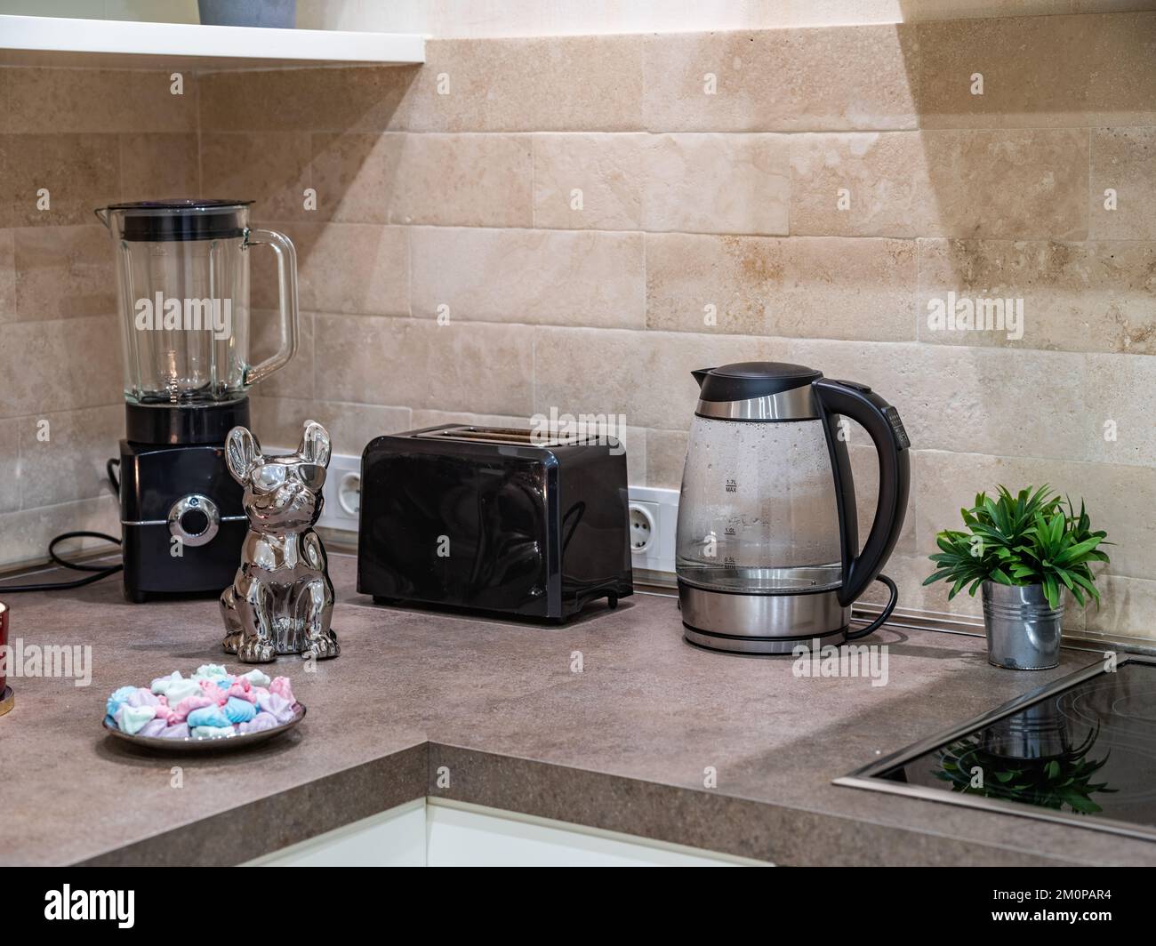 Electric kettle, toaster and blender on counter in kitchen. Beige tile ...