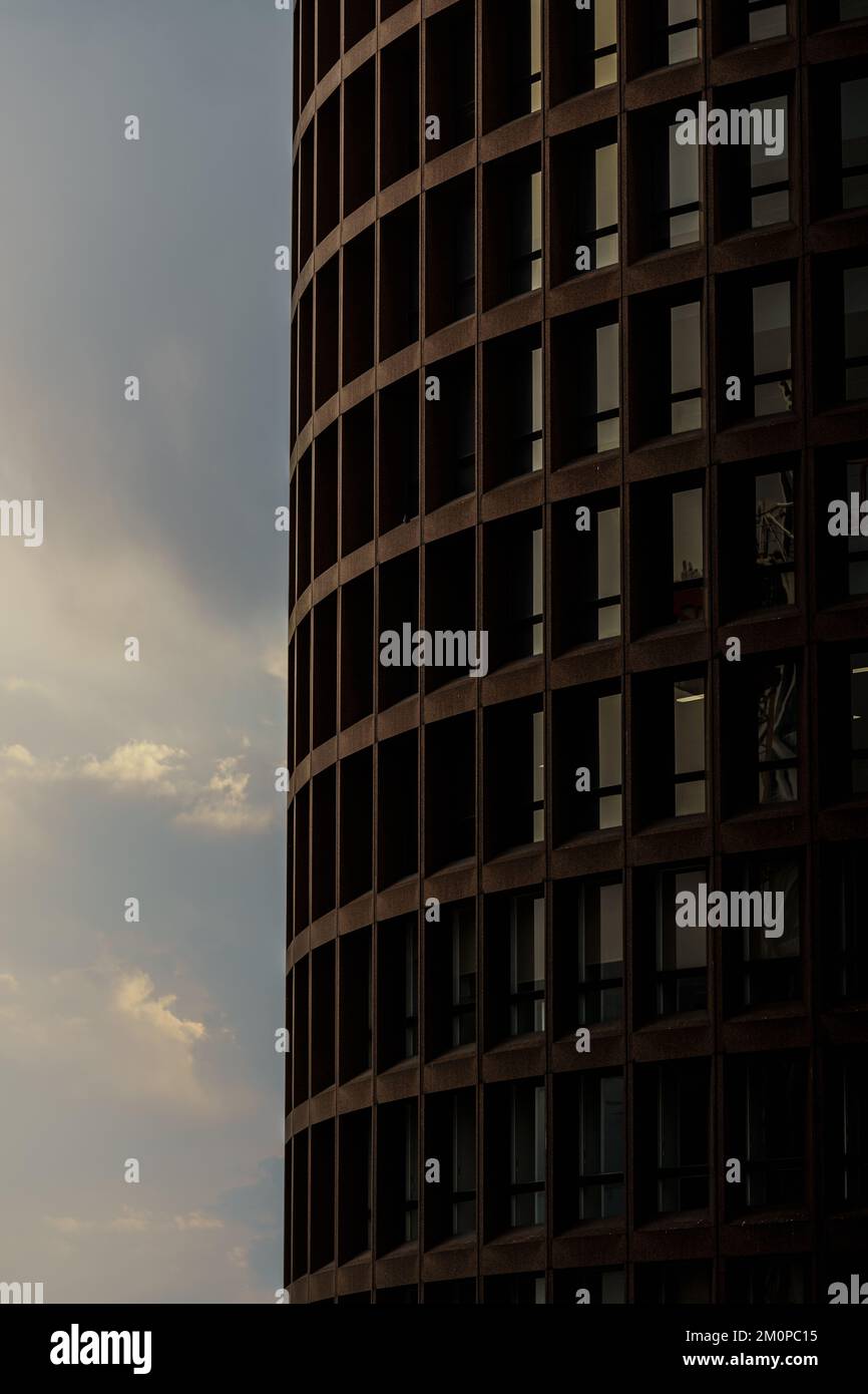 A vertical view of a tall building with cylindrical shape and many ...