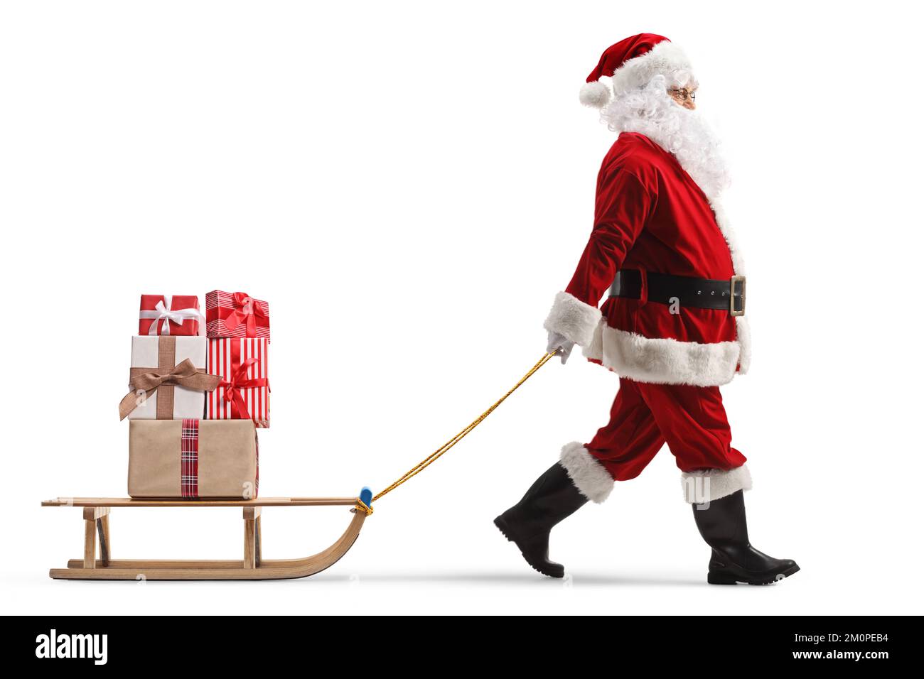 Full length profile shot of santa claus pulling a wooden sled with ...