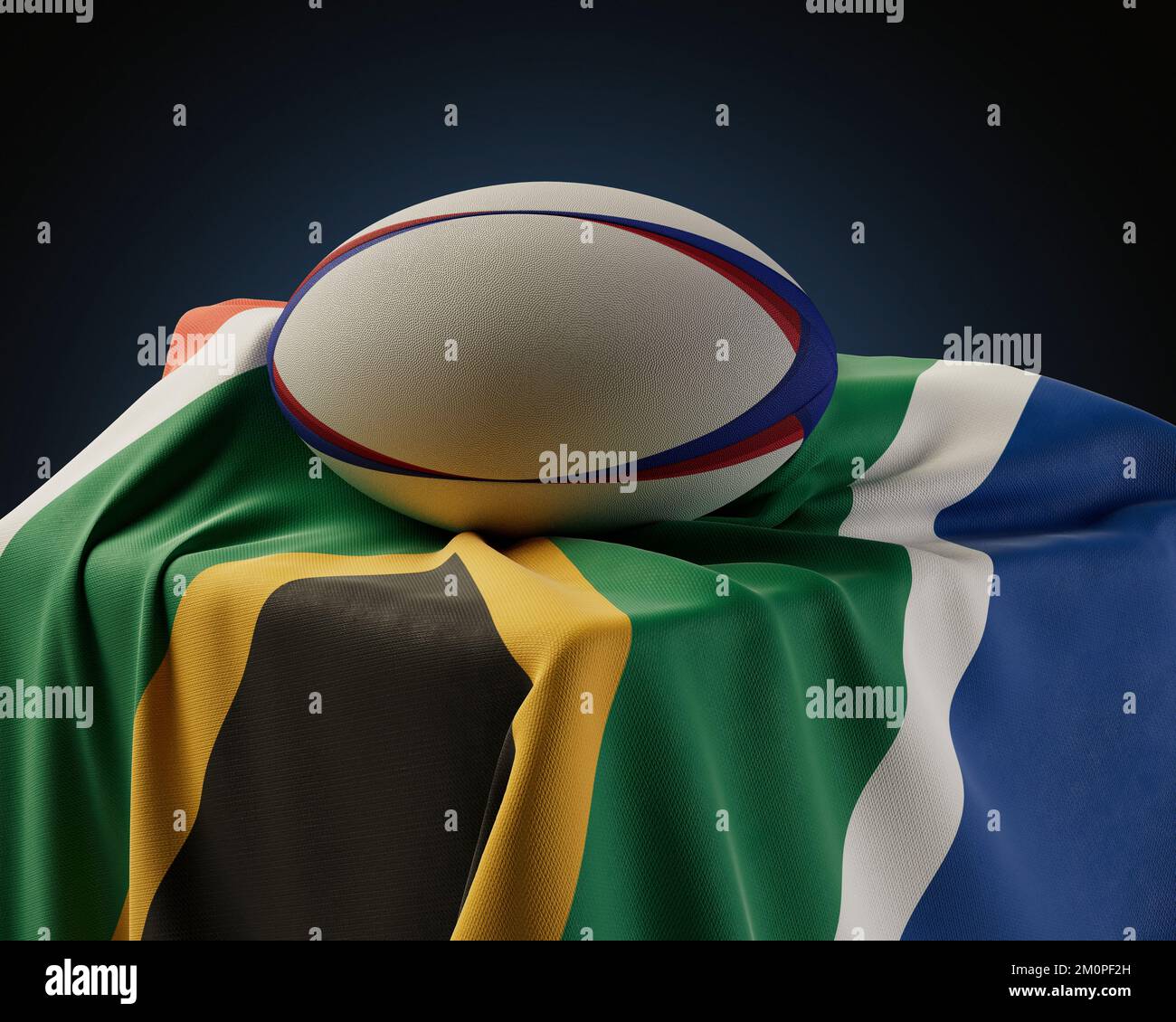 A regular rugby ball resting on a South Africa flag draped over a ...